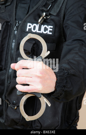 Police officer holding handcuffs Stock Photo - Alamy