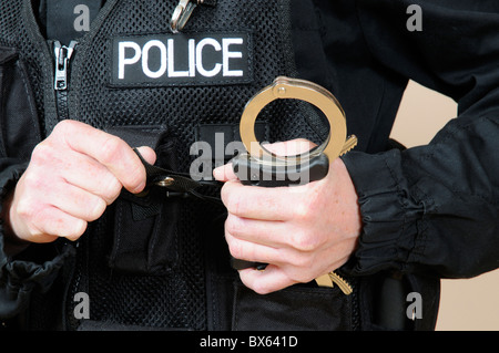 Police officer holding handcuffs Stock Photo - Alamy