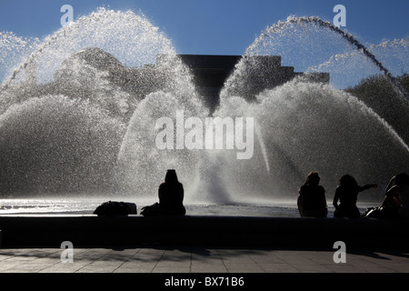 People sitting around the fountain at Washington Square Park on a hot ...