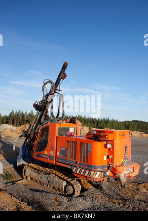 Orange Tamrock Ranger 780 rock drill machine in a rock quarry and the ...