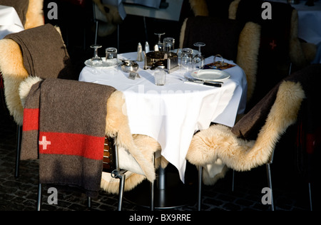 Table and chairs with fur blankets in cozy dining room decorated with ...