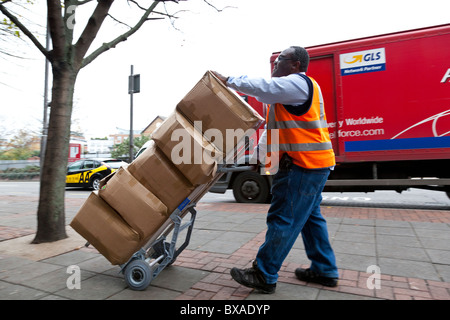 A courier uses a trolley to move heavy parcels Stock Photo - Alamy