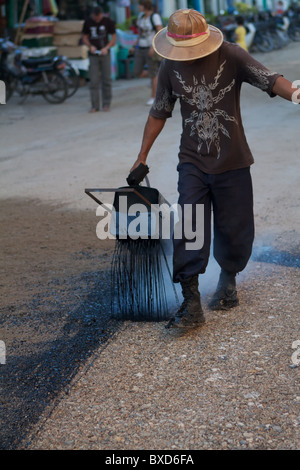 burmese man pouring tar on the road Stock Photo - Alamy