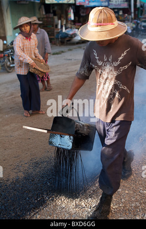 burmese man pouring tar on the road Stock Photo - Alamy
