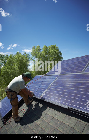 Installing solar panel, African American father and child working ...
