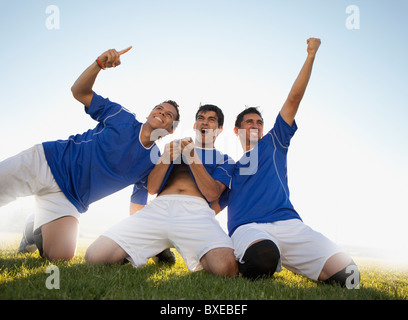Happy football player in blue celebrating Stock Photo - Alamy
