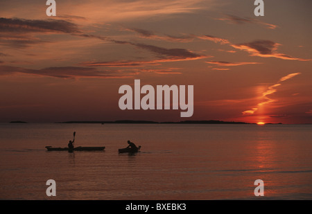 Kayaking in a red sunset, still water, red water and skies, people and ...