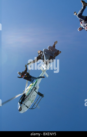 Skydivers are jumping out of a helicopter into freefall. The couple are ...
