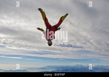 Skydiver girl is practise the head down position and flying free over ...