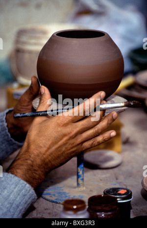 Potter working on pottery with Incan designs in artists' workshop in ...