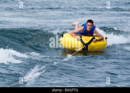 Boy riding an inflatable seabiscuit in the sea, Biscarrosse, France ...