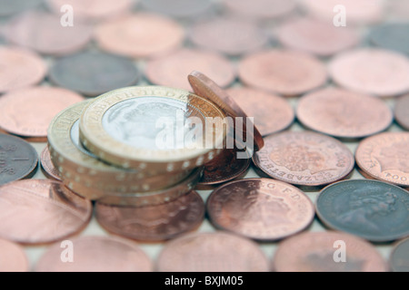 A sterling 1p coin leaning against a stack of 2p coins - all standing ...