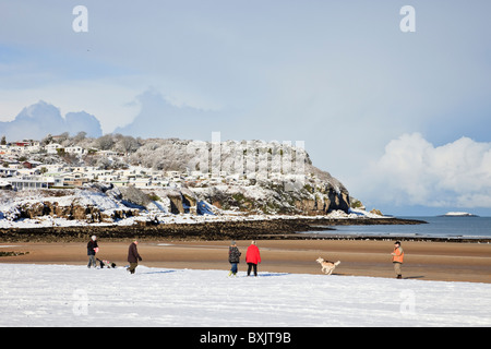 People walking on the beach at Benllech on the Isle of Anglesey. A blur ...