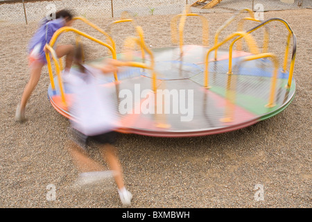 girls playing merry go round merry go round spinning run play kids ...