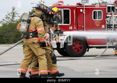 Firefighters on a hoseline fighting a fire saving lives Stock Photo - Alamy