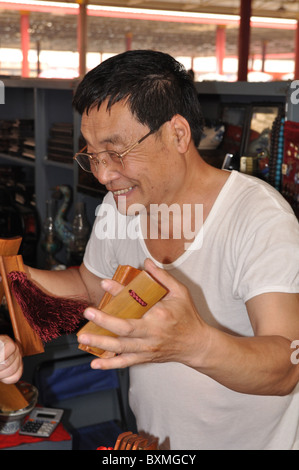 Chinese musician playing Chinese castanets made of bamboo, Beijing ...