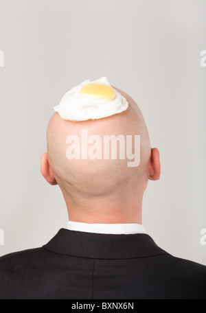 Bald man with fried eggs on top of head looking at camera Stock Photo ...