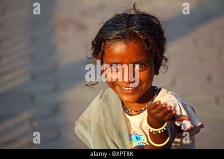 Indian street girl begging for money with rupee coins in her hand.Black ...