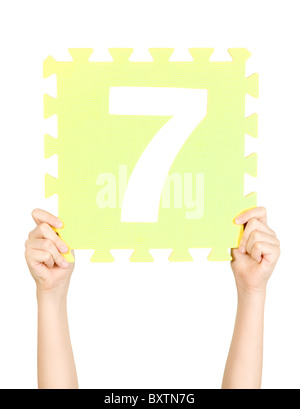 Number seven in hand. Hand holding white number 7 on red background ...