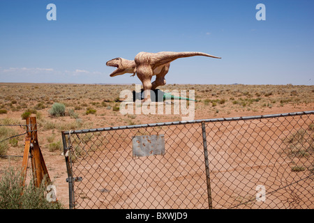 USA, Arizona, Holbrook, Sculpture of fighting dinosaurs on dusty desert ...