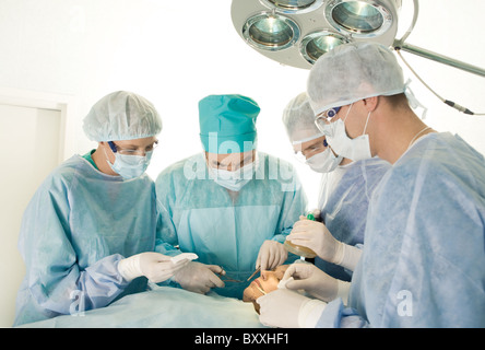 Medical professionals performing an operation on patient in operation ...