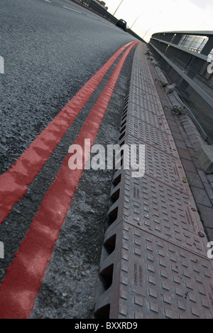 Close up of double red lines road markings indicating a Red Route and ...