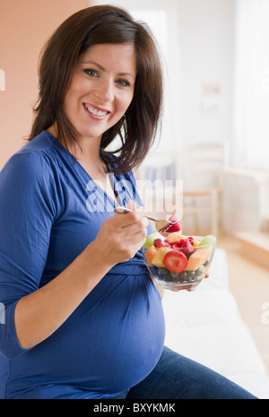 Beautiful young pregnant woman with bowl of fresh vegetable salad in ...
