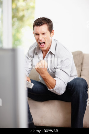 Excited man watching a football match Stock Photo - Alamy