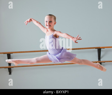 child, girl indoors leaping, jumping on furniture, sofa, being ...