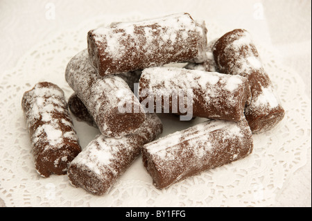 Chocolate logs dusted with icing sugar on a white background Stock ...