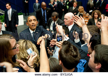 President Barack Obama reaches to shake hands with people in a crowd ...