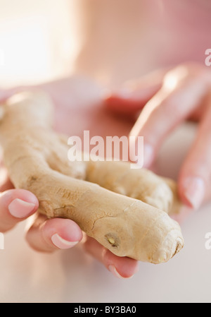 Hand holding ginger root Stock Photo - Alamy