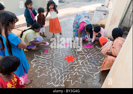 Indian child making rangoli in front of home during festival season ...