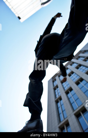 Low angle view of businessman jumping Stock Photo - Alamy