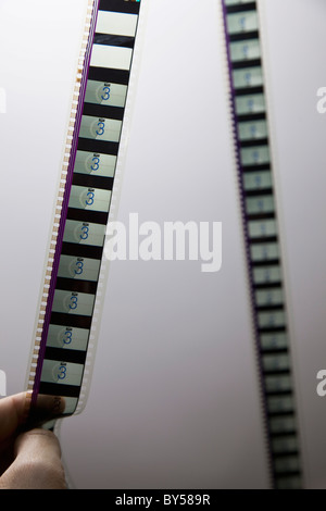 A vertical shot of a celluloid film strip against the gear on the wall ...