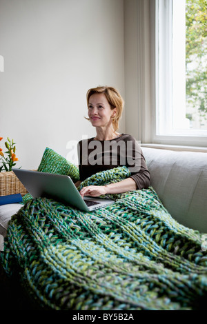 Portrait of mature woman reclining on white luxury sofa Stock Photo - Alamy