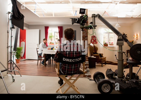 A director on a film set watching actors perform a scene Stock Photo ...