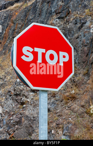 Red octagonal Stop sign on a metal pole with cloudy sky in the ...
