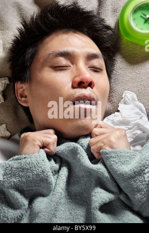 A sick male sleeping with clock near him Stock Photo - Alamy