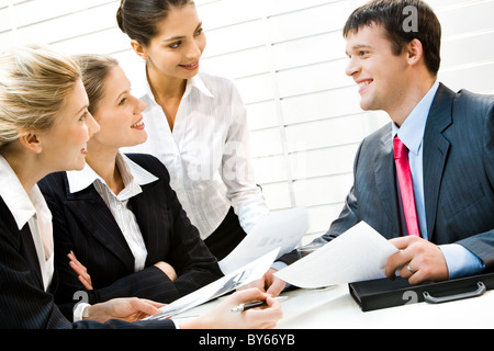Portrait of confident co-workers interacting with each other at meeting ...