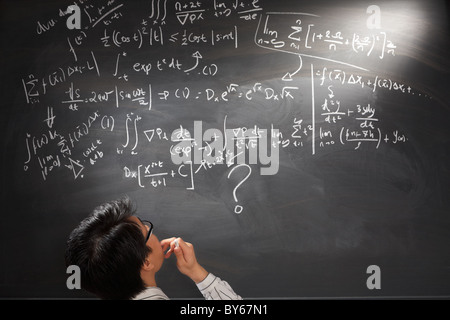 Thinking at difficult complex mathematics equation on blackboard Stock ...