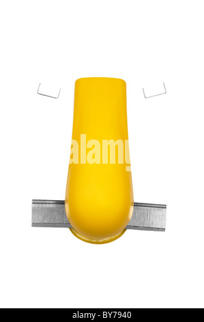 Office stapler with staples on yellow background Stock Photo - Alamy