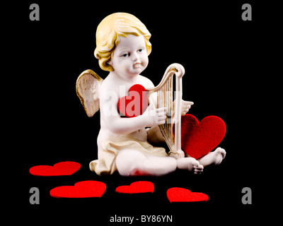 Ceramic cupid figure with felt red heart and tea rose on black ...