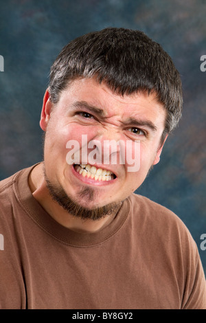 Man grits his teeth with a painful expression Stock Photo - Alamy