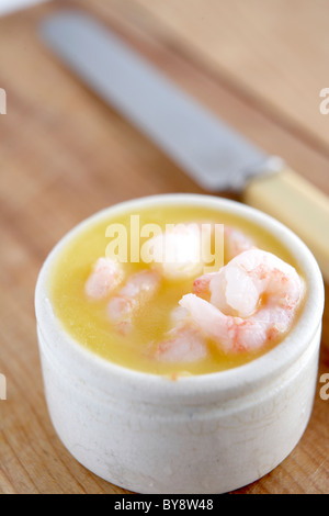 Potted prawns in white container on wooden background with knife Stock ...