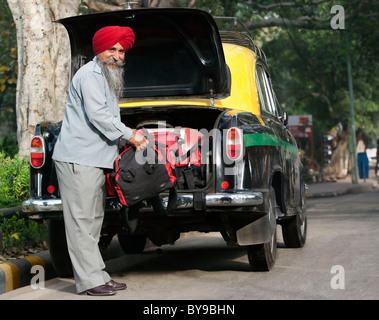 Sikh taxi driver loading luggage into the dickie Stock Photo - Alamy