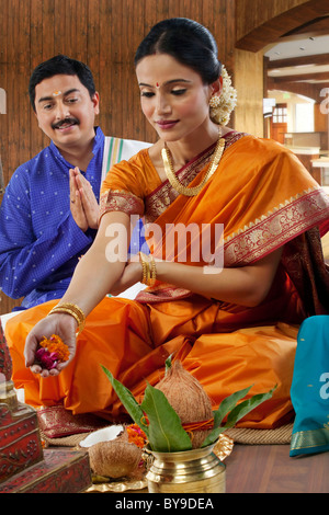 South Asian Indian woman offering petals of Mokara Orchid flower ...