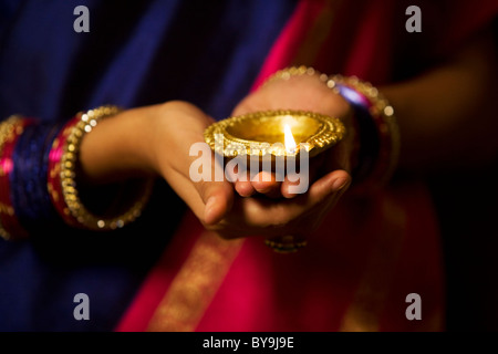 hands holding diwali diya or indian traditional oil lamp made of clay ...