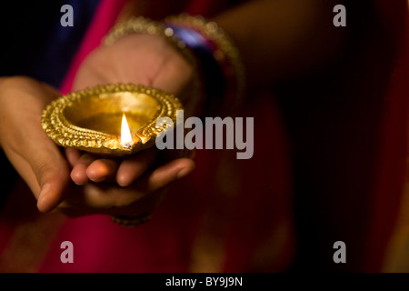 hands holding diwali diya or indian traditional oil lamp made of clay ...