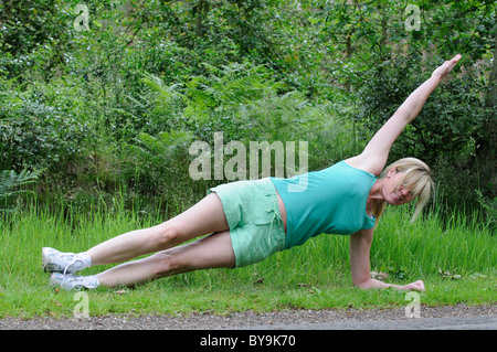 Woman jumping on the spot to keep & stay fit and healthy wearing green ...